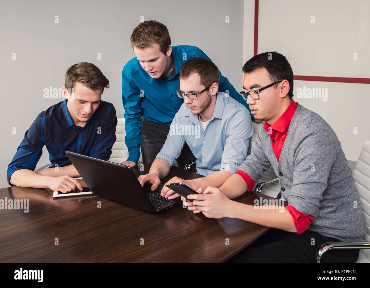 Young men who are millennial business professionals working together in ...