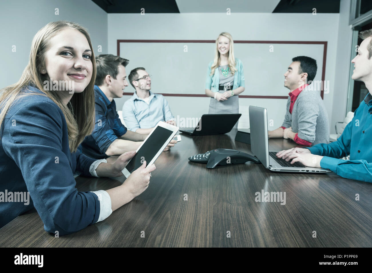 Young millennial business woman looking at the camera while another ...