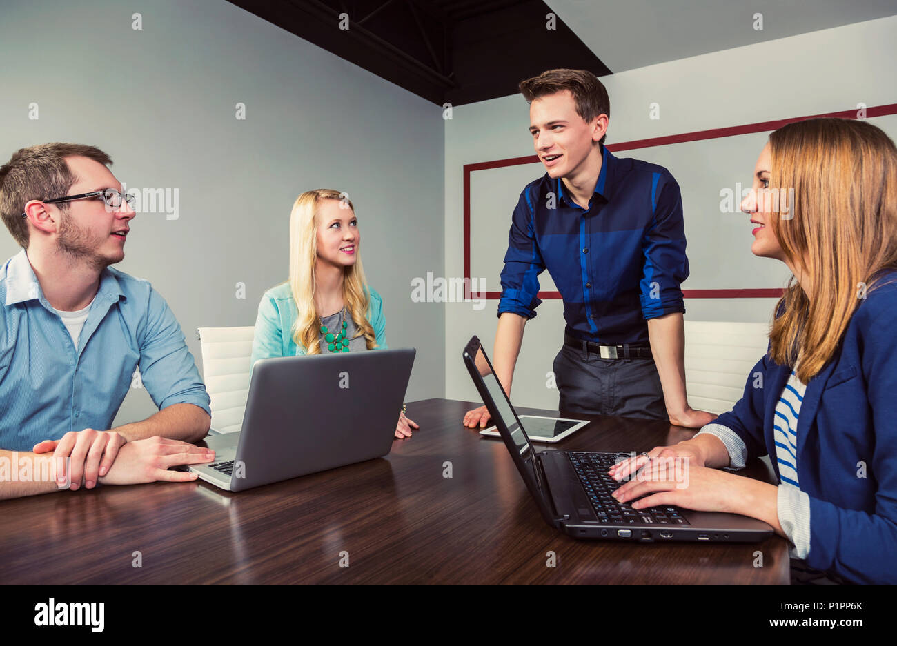 Young millennial businessman speaking to a group of young professionals ...