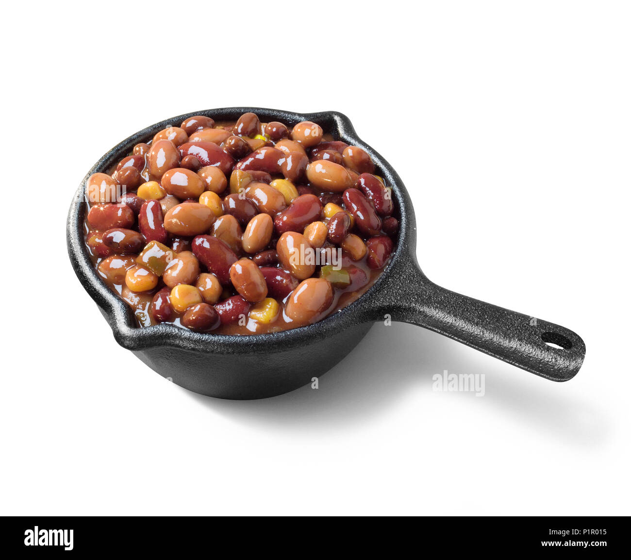 Baked beans in a cast iron pot with handle against a white background ...