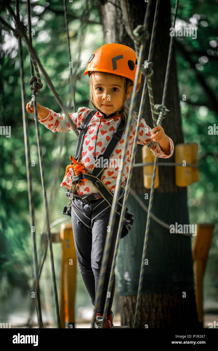sports happy kid climbs through the ropes, the beautiful girl in the ...
