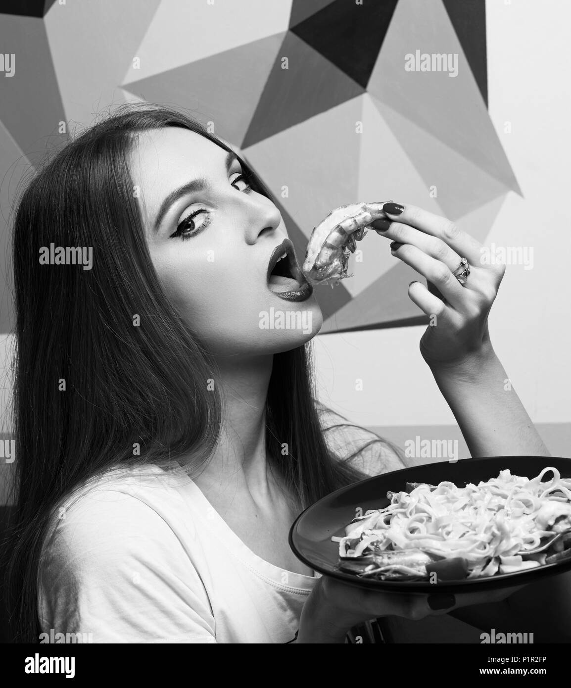 Gorgeous long haired woman with closed eyes holding plate of Italian ...