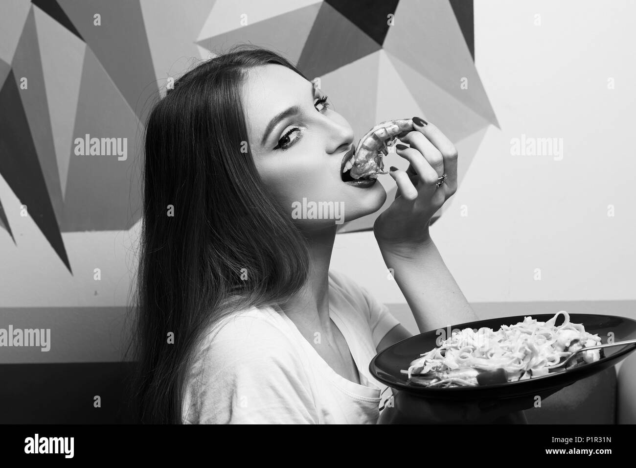 Gorgeous long haired woman with closed eyes holding plate of Italian ...
