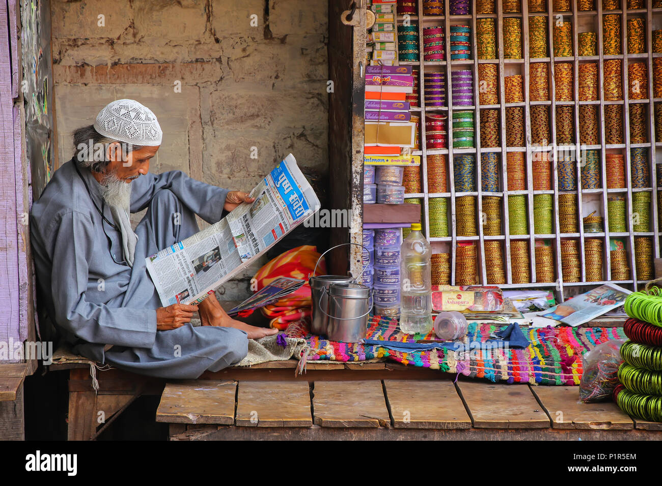 Local man reading newspaper at the street market in Fatehpur Sikri ...