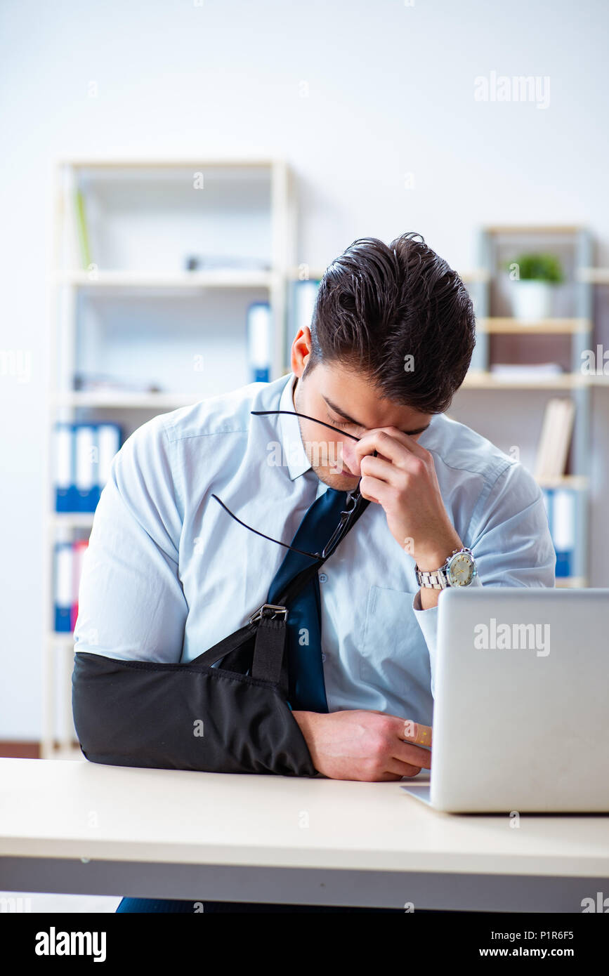 Businessman with broken arm working in office Stock Photo - Alamy