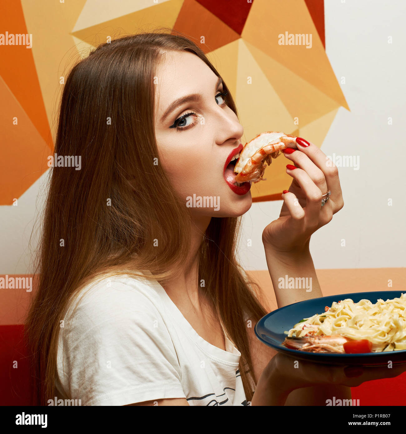 Gorgeous long haired woman with closed eyes holding plate of Italian ...