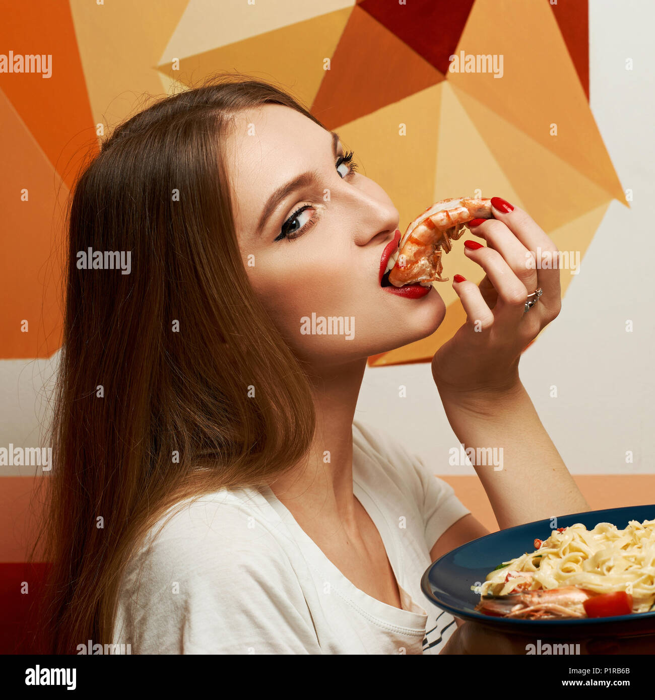 Gorgeous long haired woman with closed eyes holding plate of Italian ...
