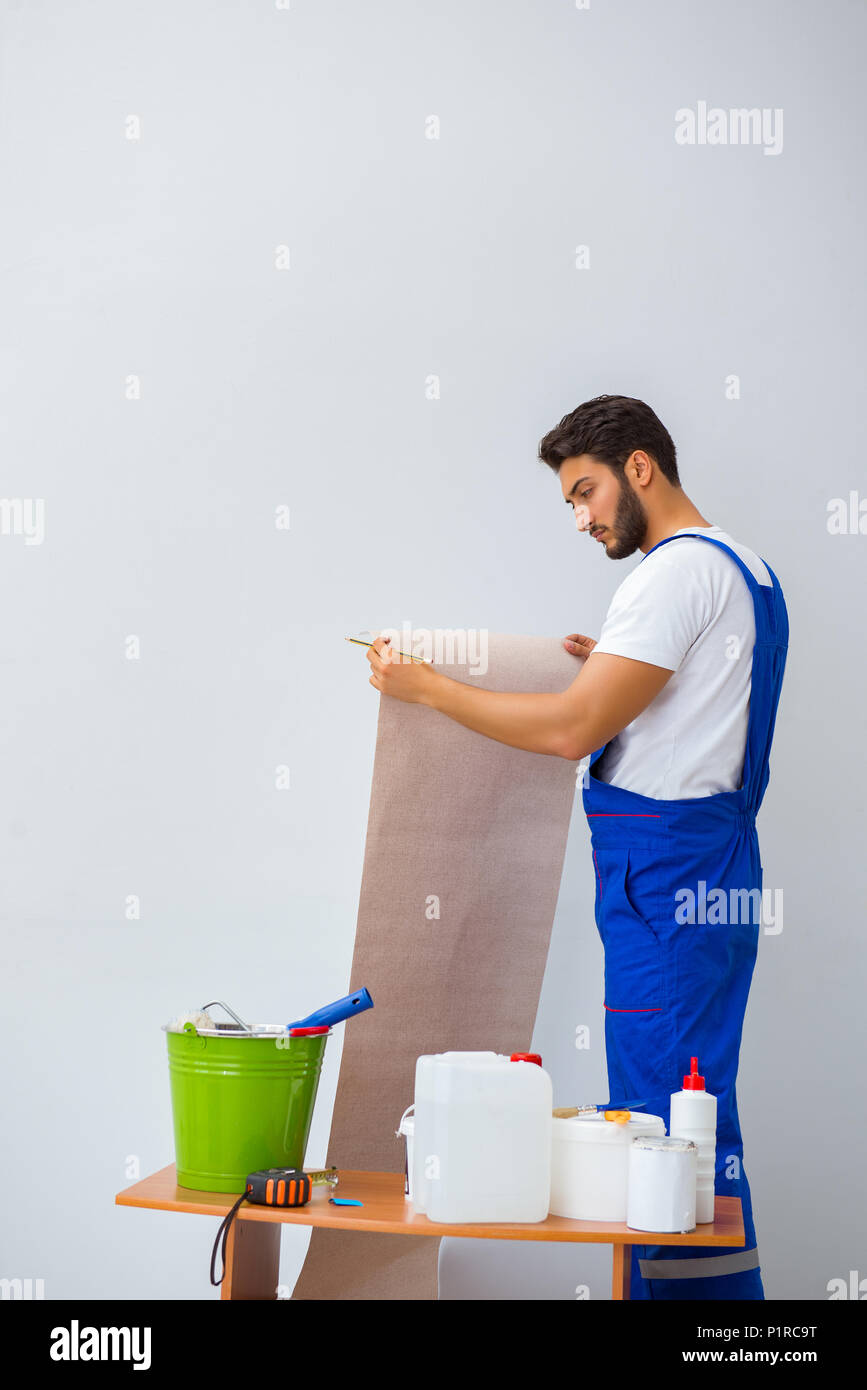 Worker working on wallpaper during refurbishment Stock Photo - Alamy