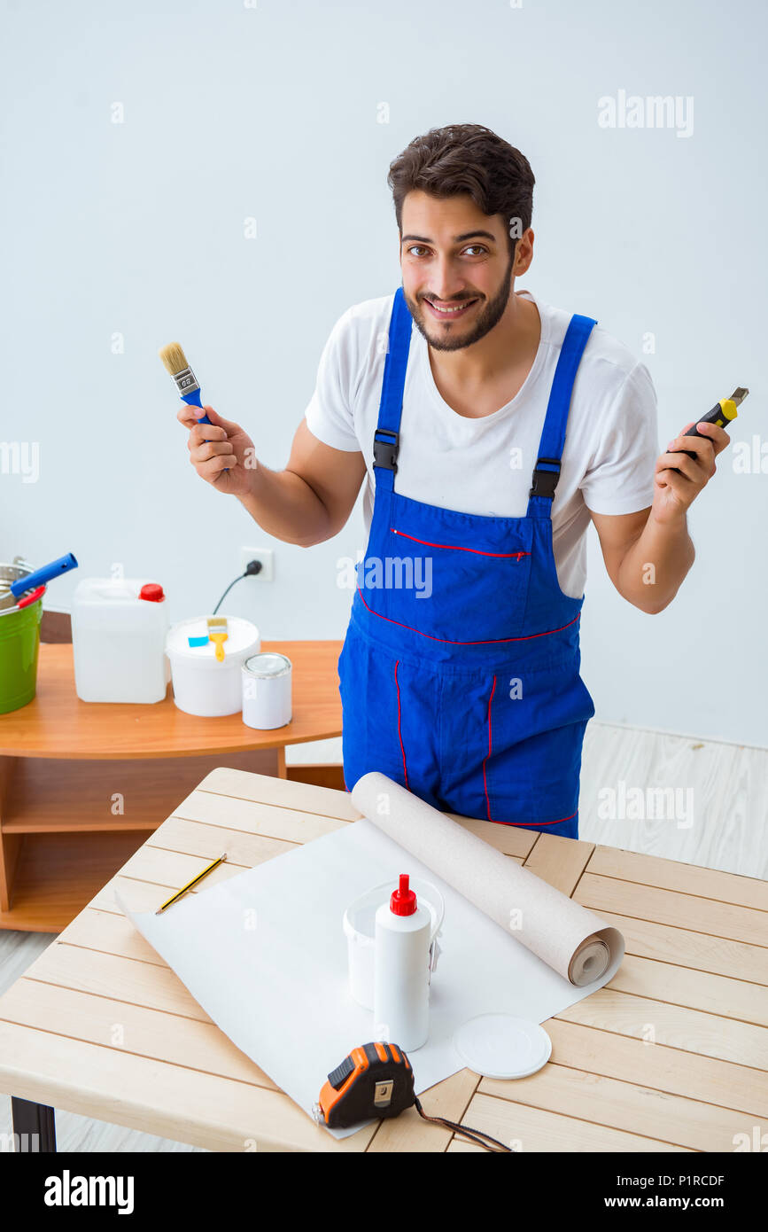 Worker working on wallpaper during refurbishment Stock Photo - Alamy