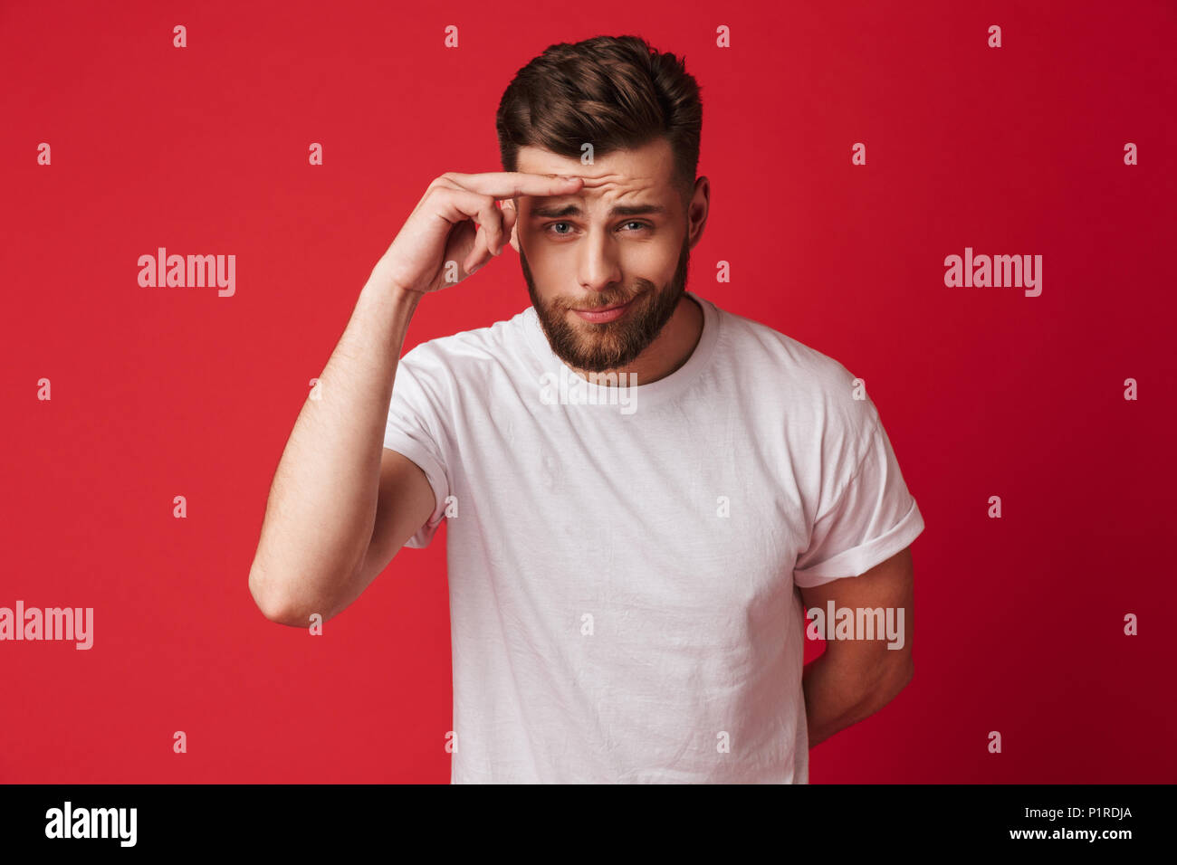 Image of confused young handsome man standing isolated over red wall ...