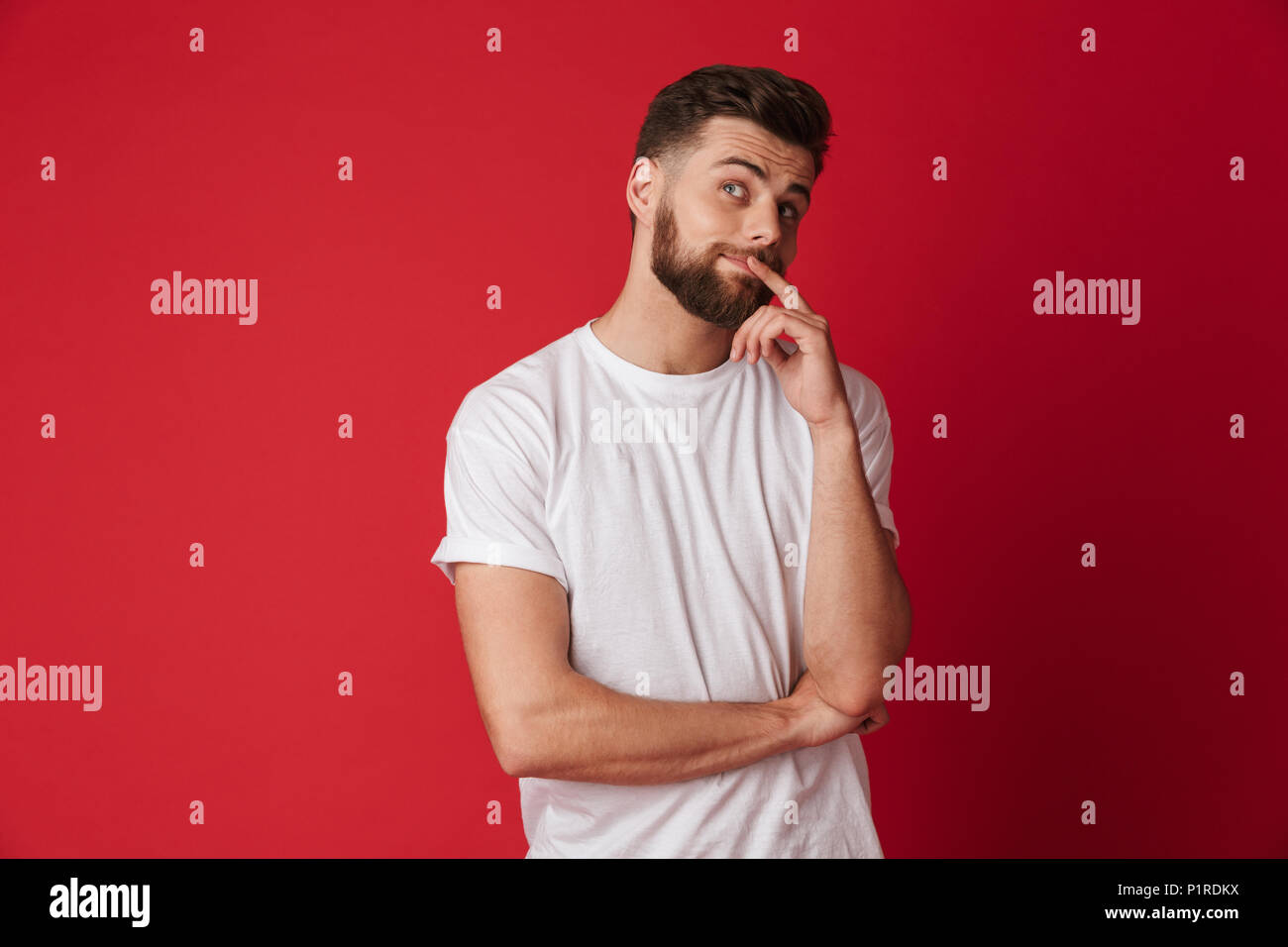 Image of thinking young handsome man standing isolated over red wall ...