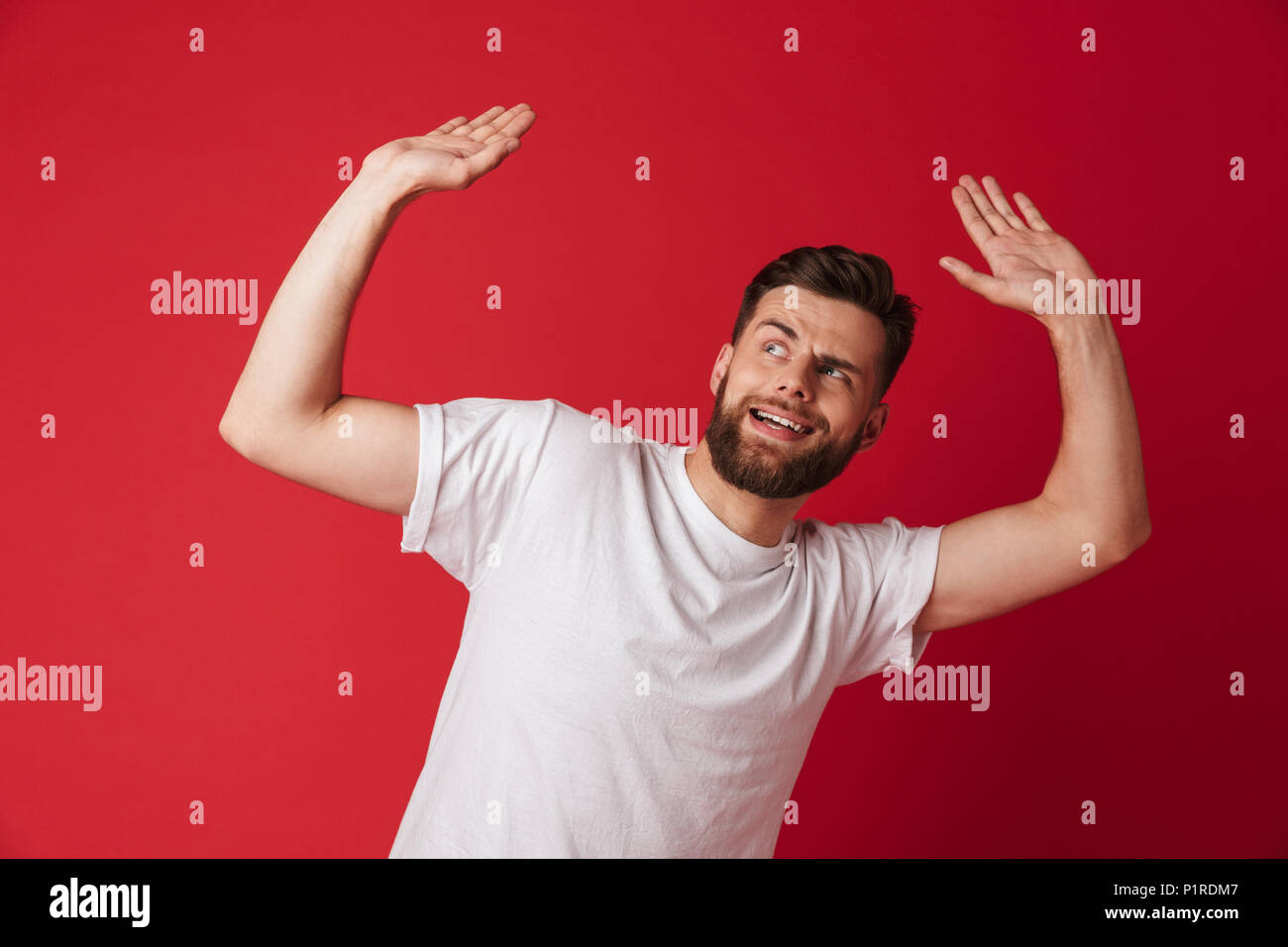 Image of confused young man standing isolated over red wall background ...
