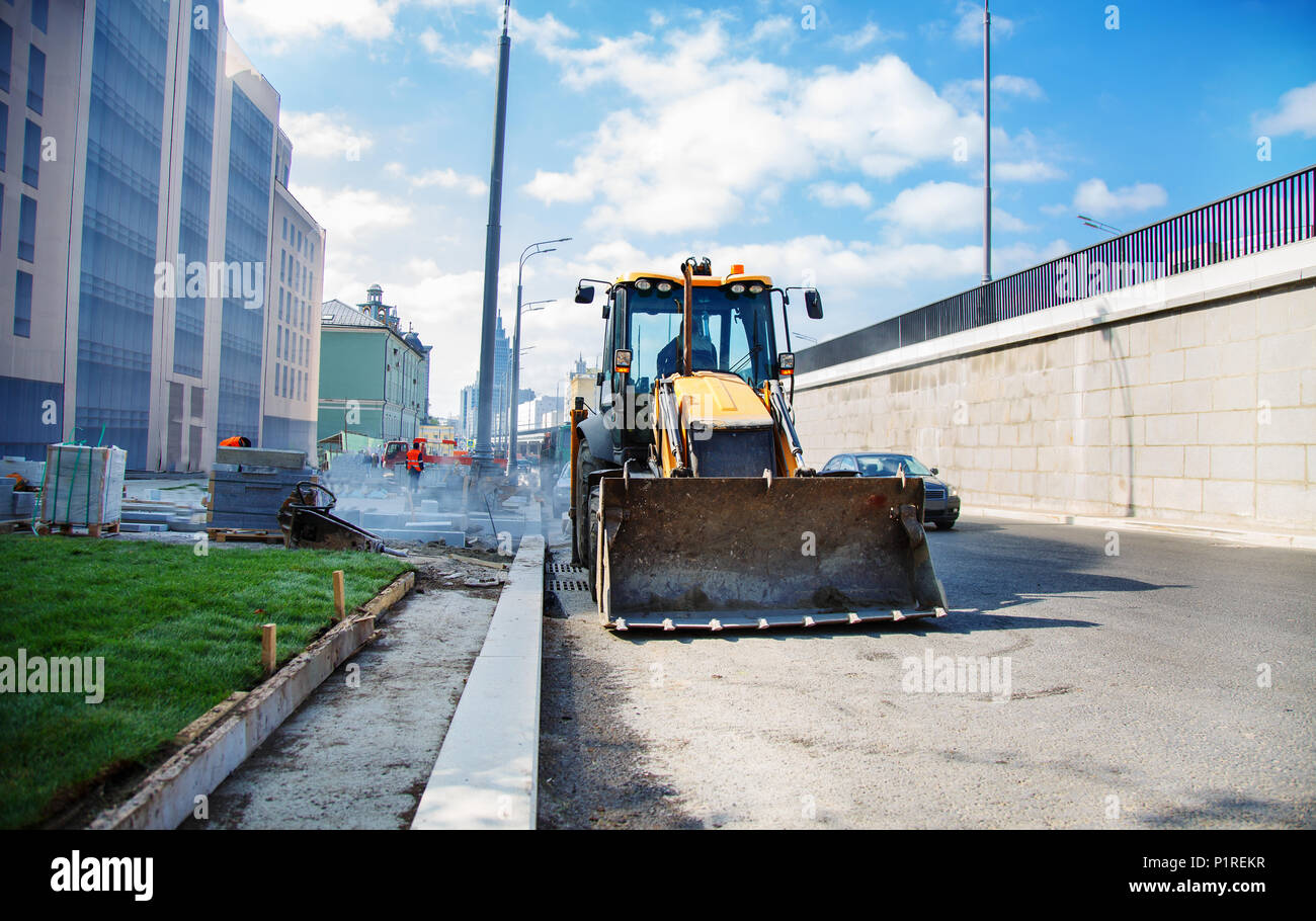 Excavator at the road construction in the city Stock Photo - Alamy