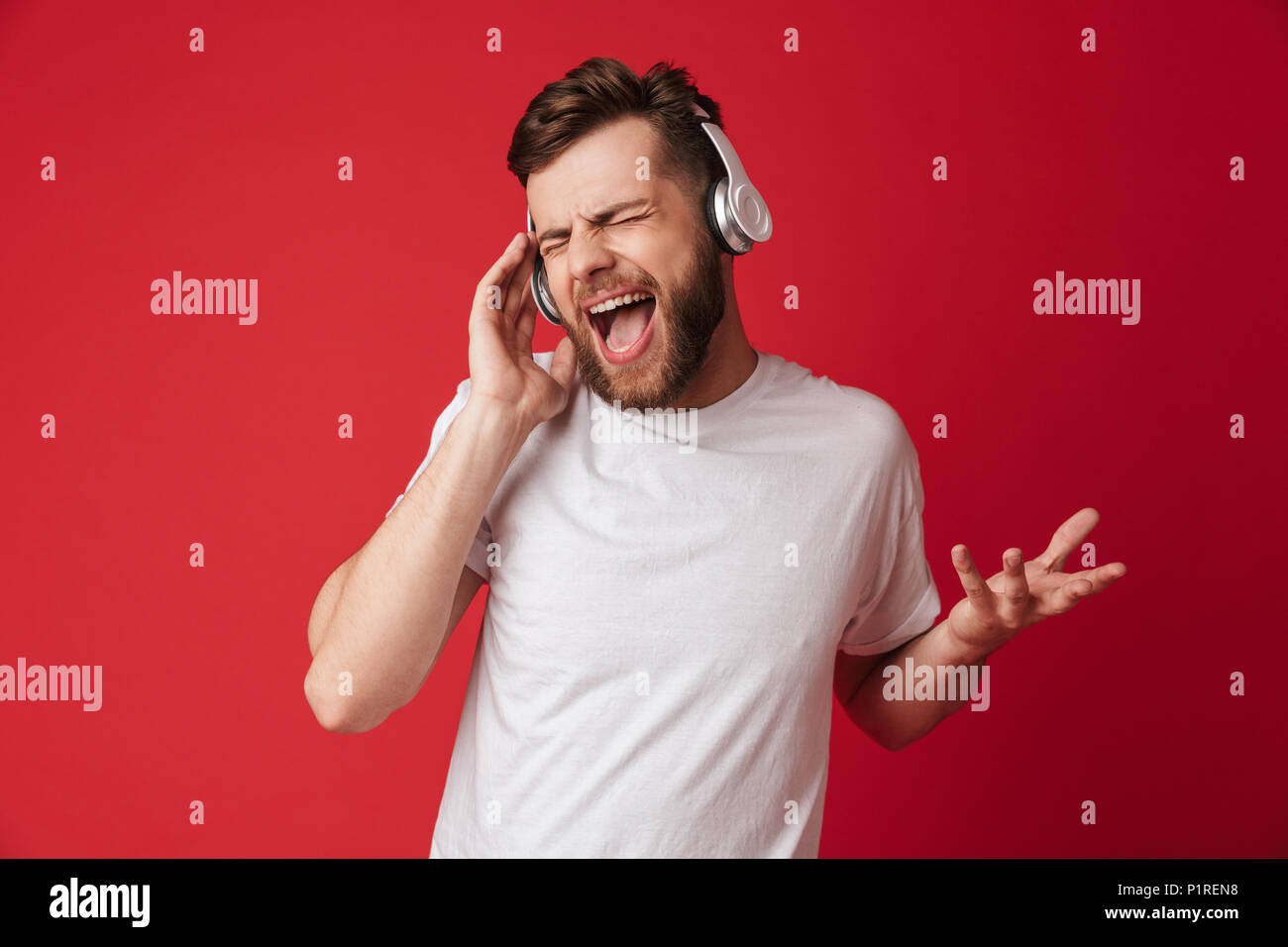 Image of emotional screaming young man isolated over red wall ...