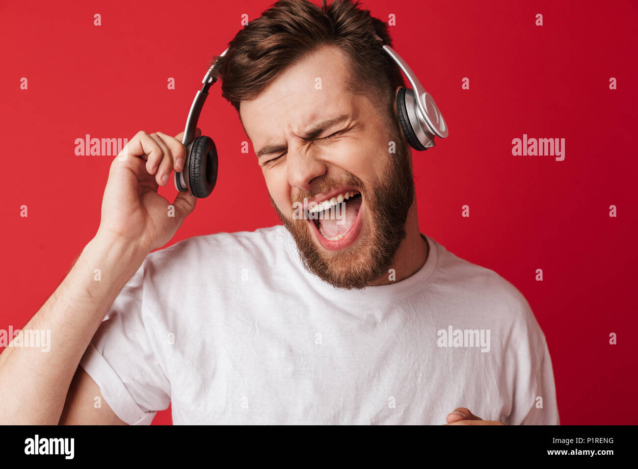 Image of emotional screaming young man isolated over red wall ...