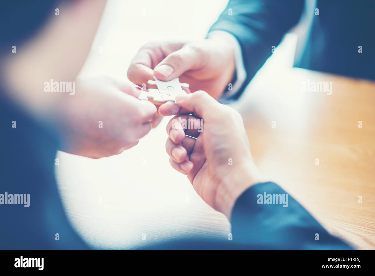 hands trying to connect couple puzzle piece with background, one part ...