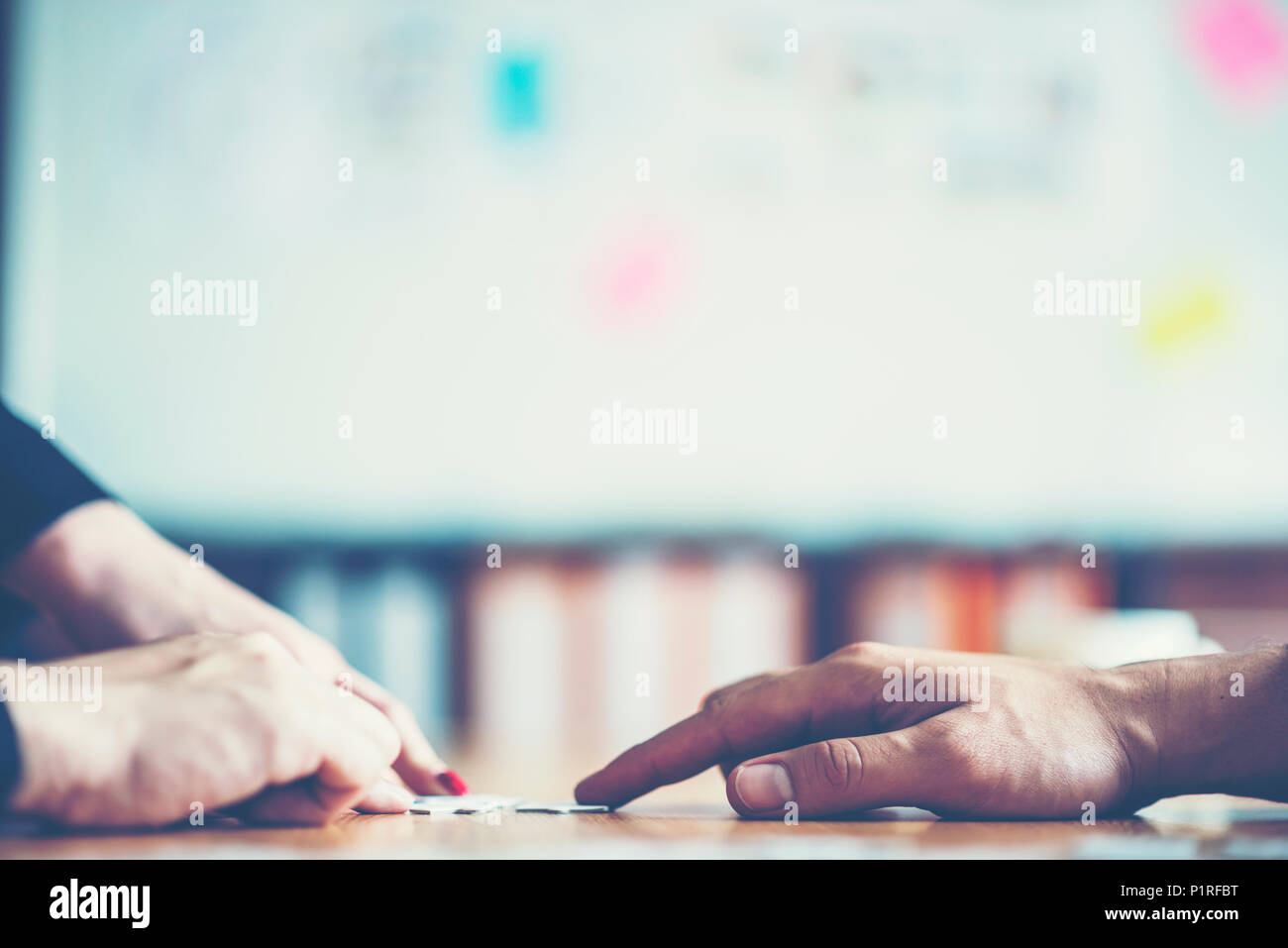 hands trying to connect couple puzzle piece with background, one part ...
