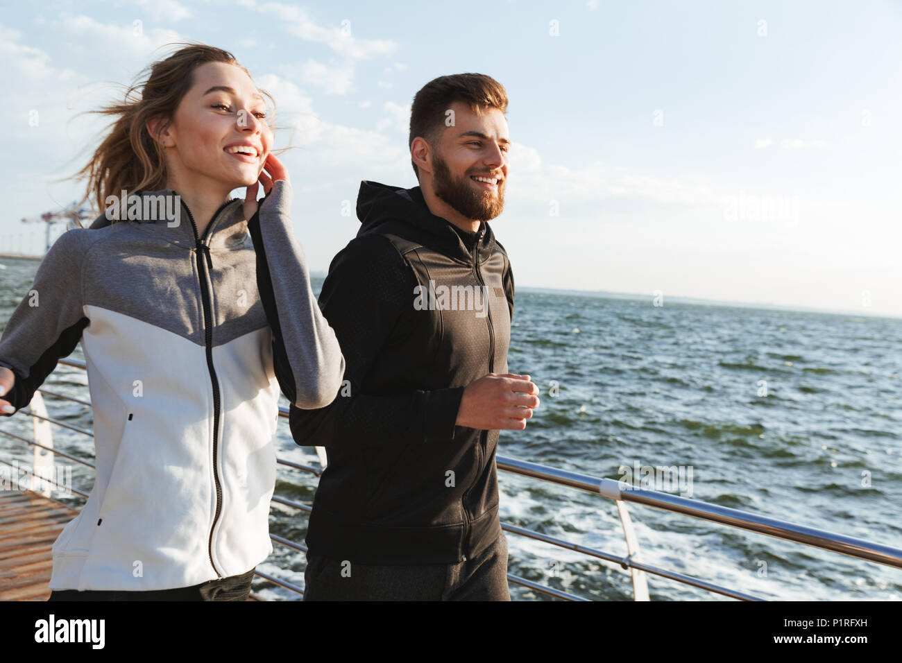 Happy young sports couple jogging together at the beach Stock Photo - Alamy