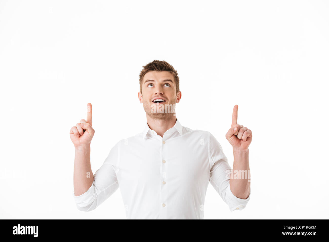 Portrait of an excited young man pointing up at copy space isolated ...