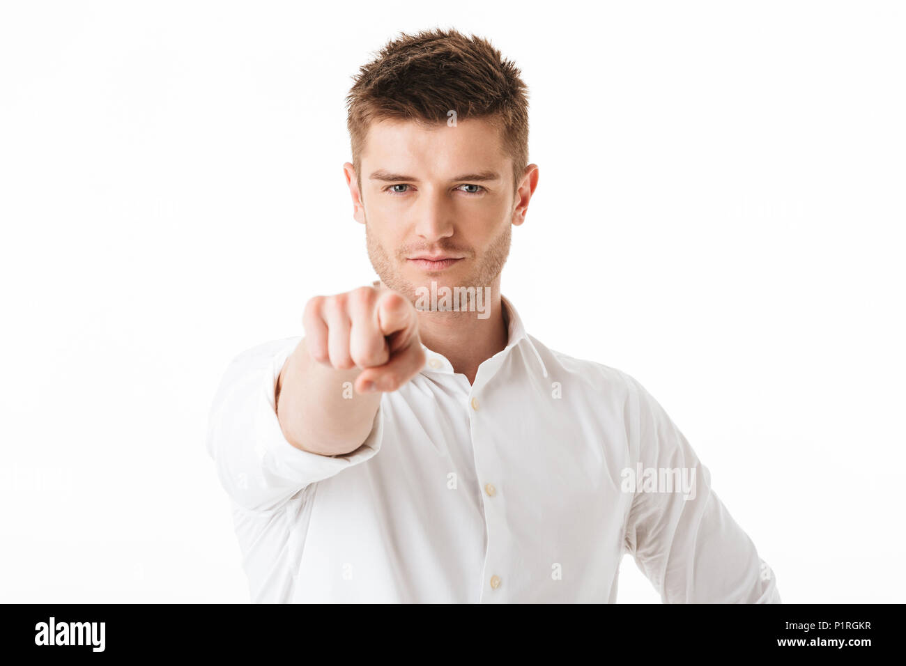 Portrait of a confident young man pointing finger at camera isolated ...