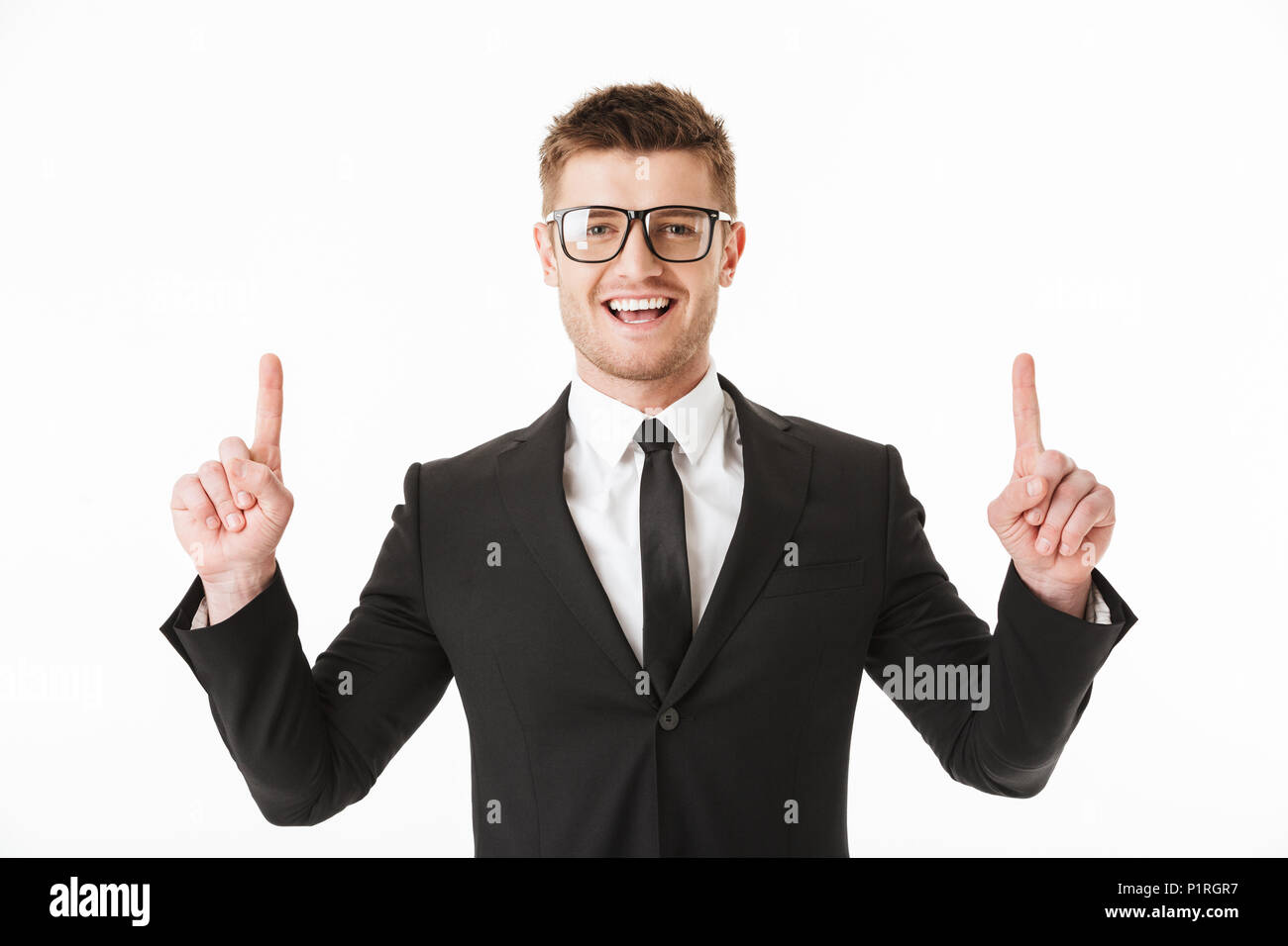 Portrait of a happy young businessman in suit and eyewear pointing ...