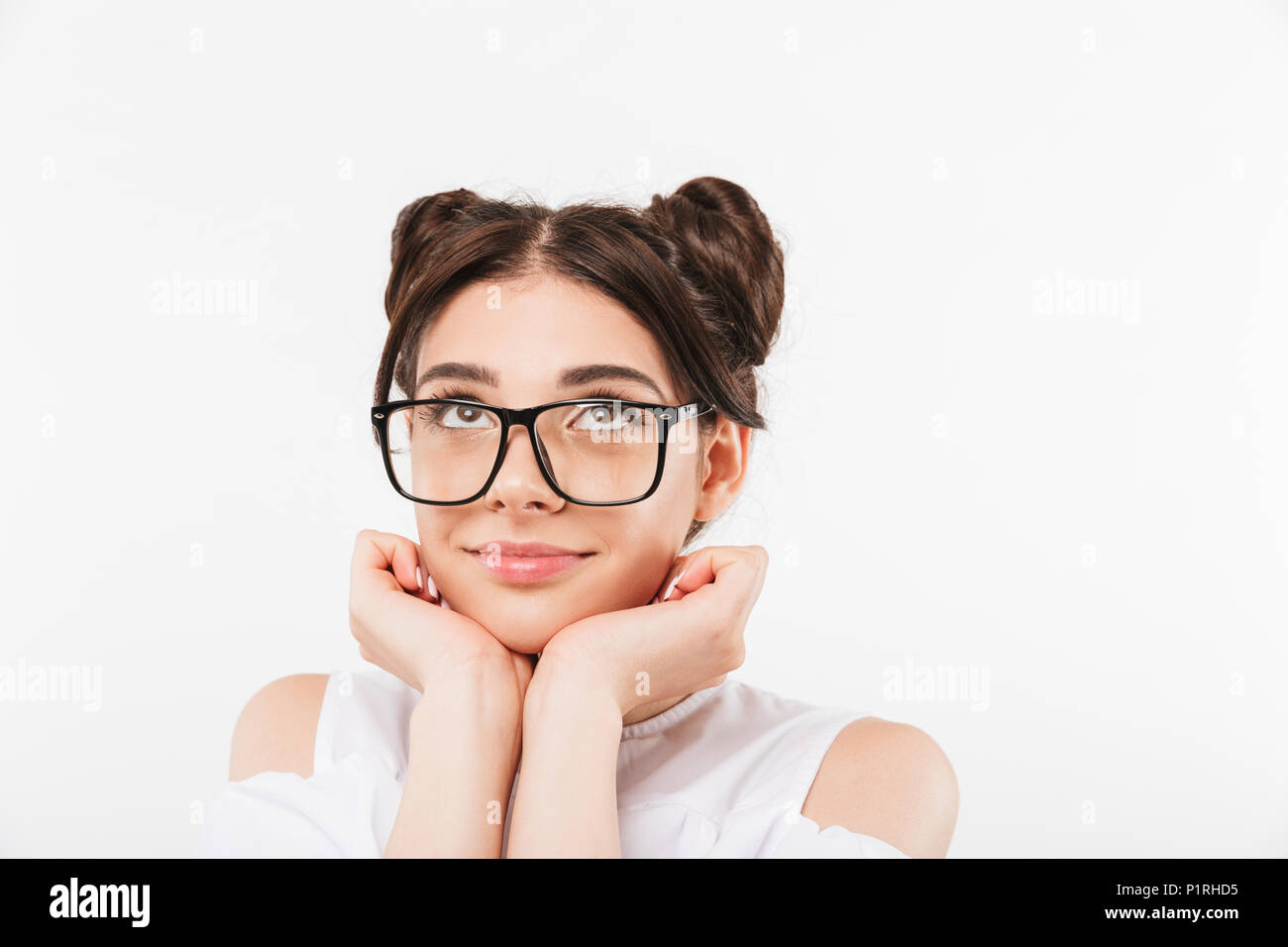 Portrait of a smiling young girl in sunglasses looking up at copy space ...
