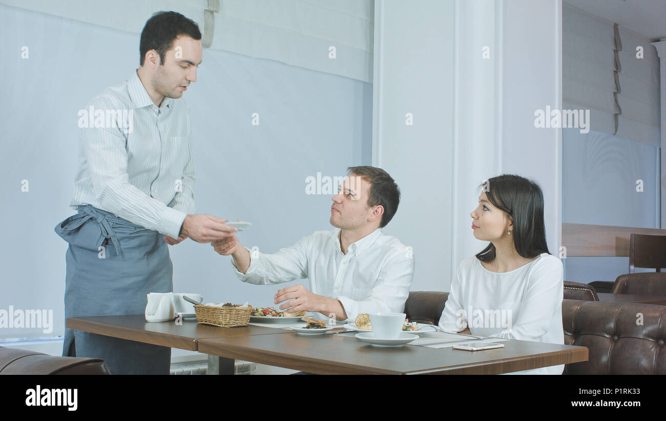 Young couple not liking their food and asking waiter to take it away ...