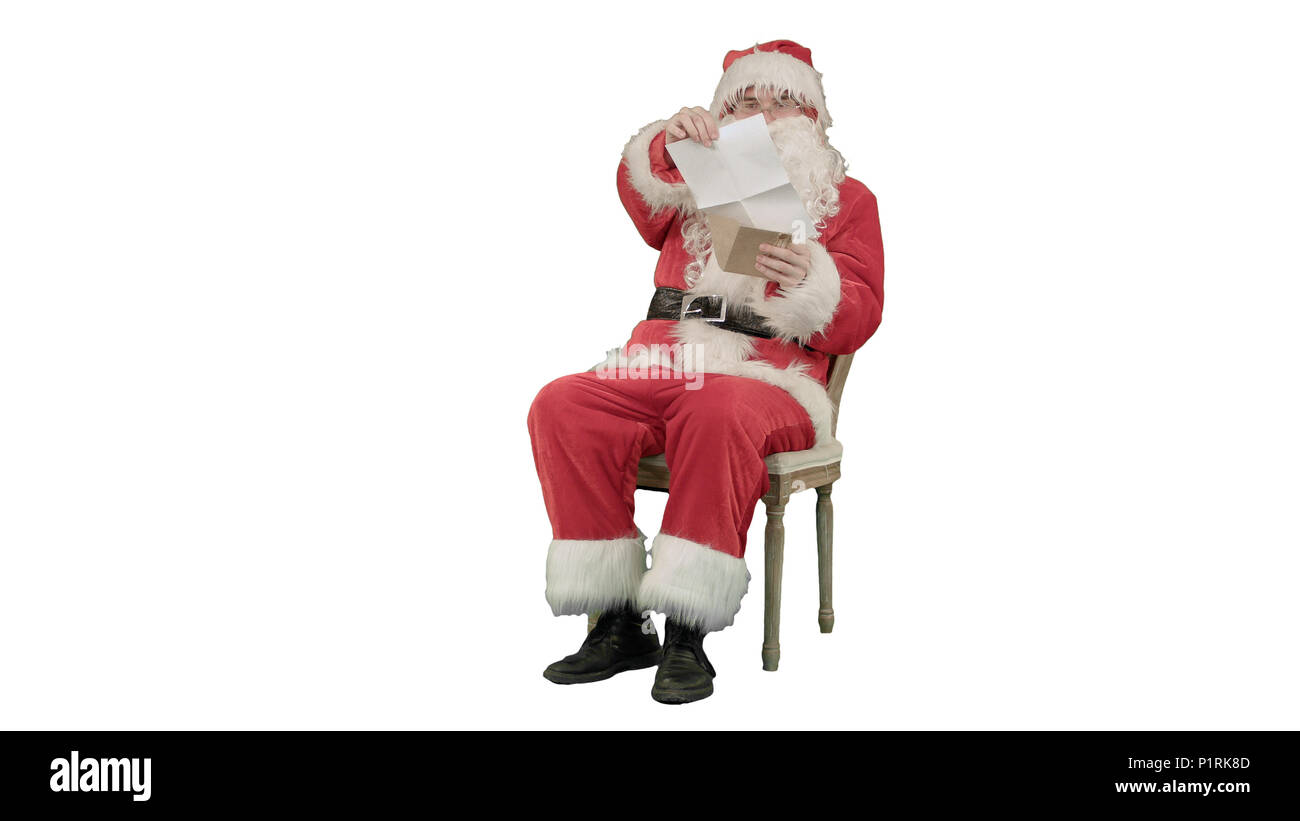 Santa Claus sitting on chair with letters in hands on white background ...