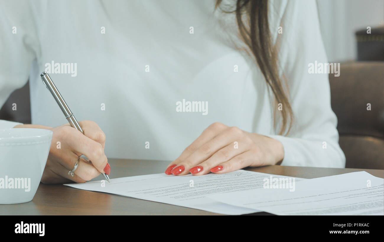 Woman hand putting signature on contract Stock Photo - Alamy