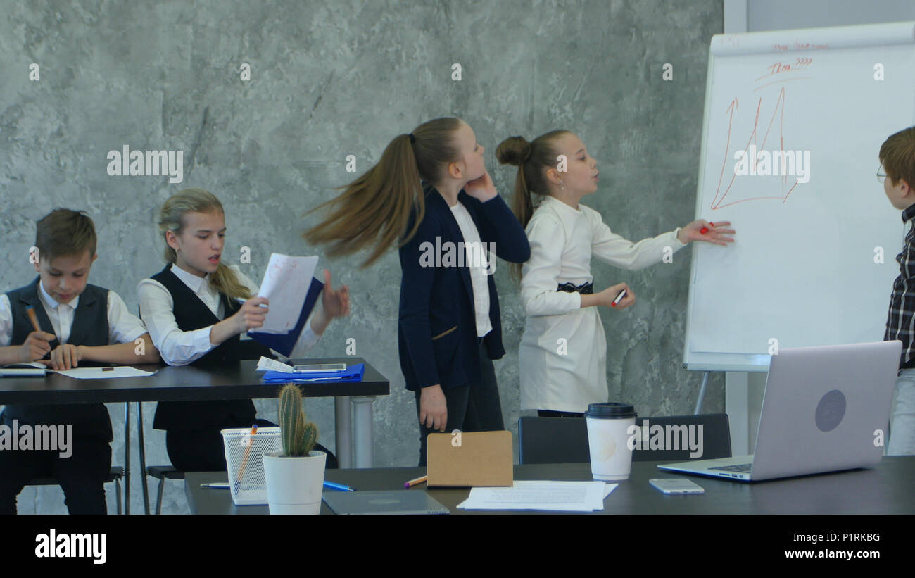Kids working hard in office, discussing serious problems together ...