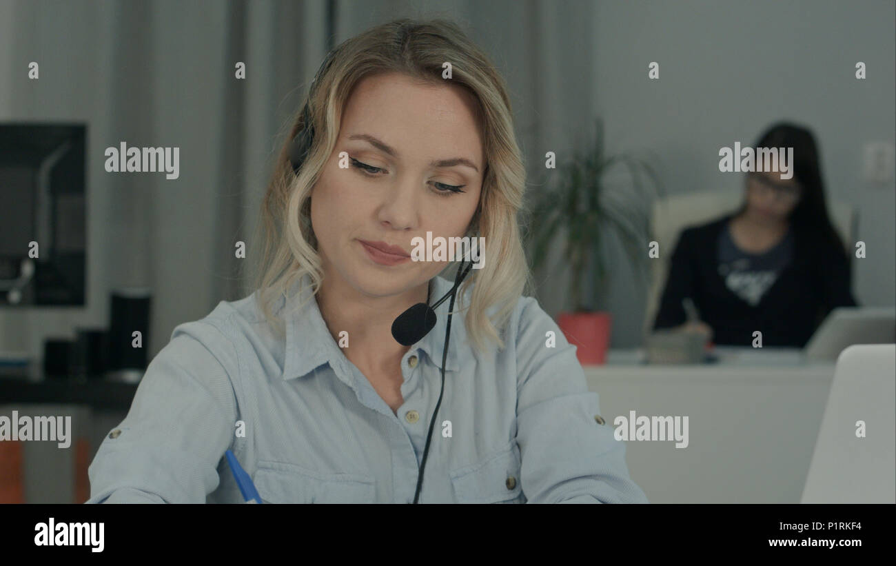 Call center employee making notes while talking with customer Stock ...