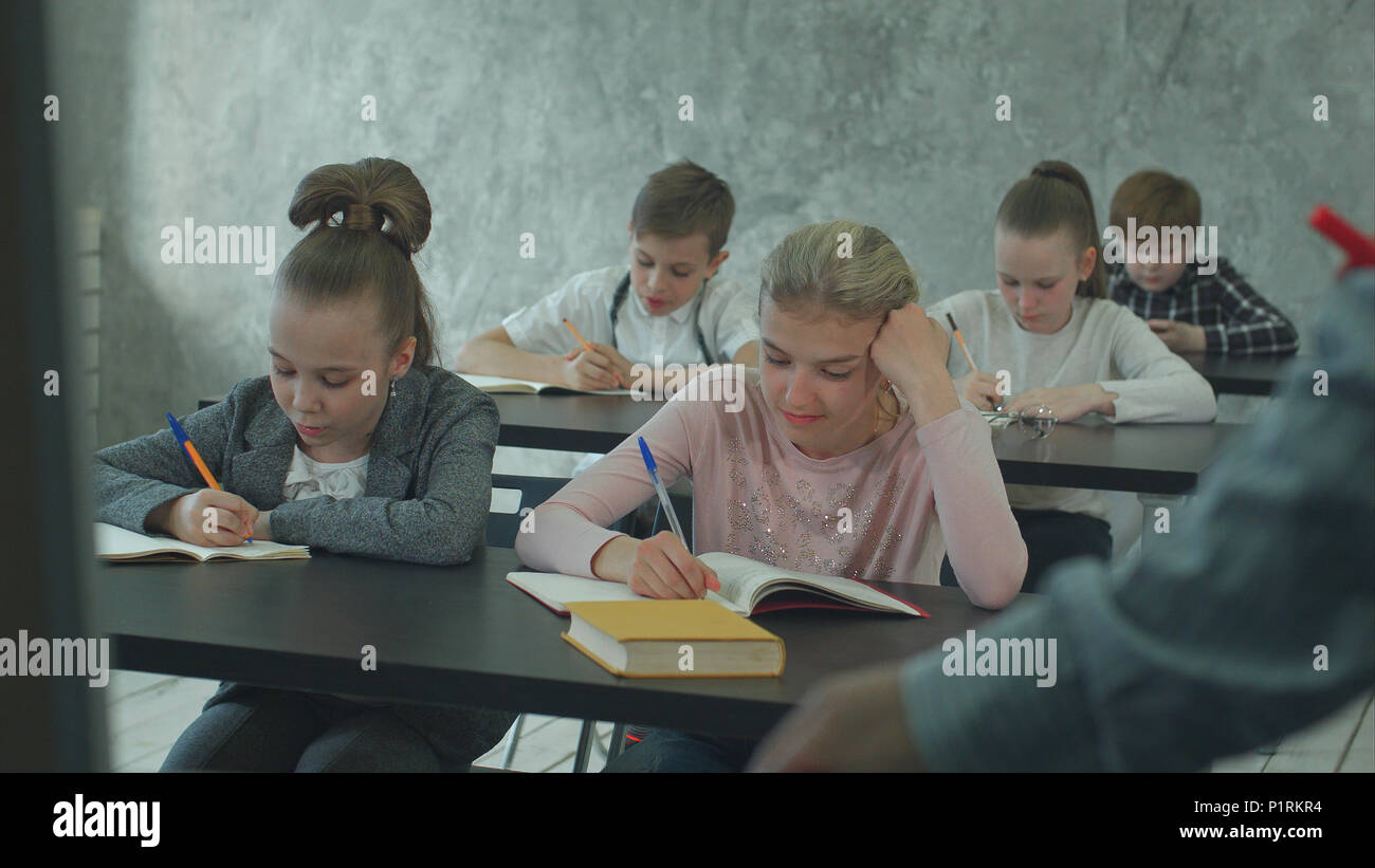 Children writing notes in class during lesson Stock Photo - Alamy