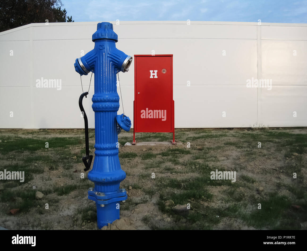 A blue hydrant with a sealed cap and red square hydrant storage|bar ...