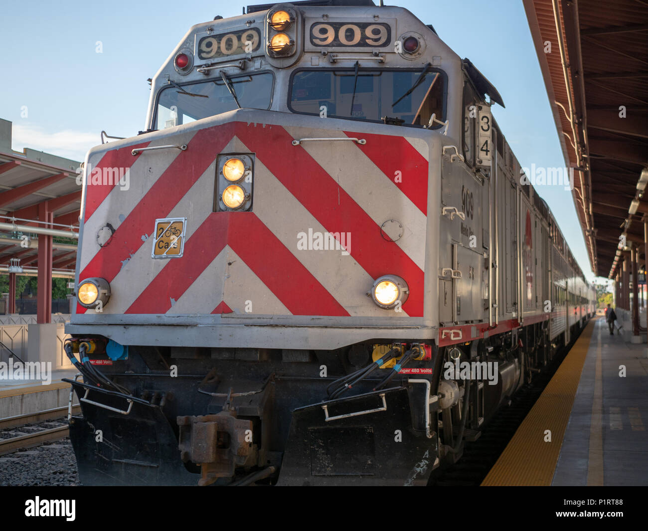 View of front of large locomotive train arriving at outdoor station ...