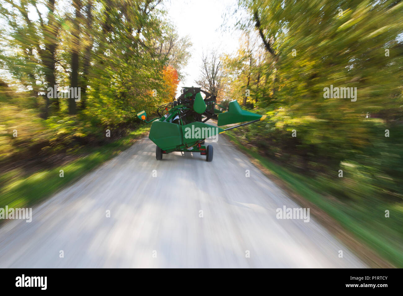 Moving farm equipment on a rural road to a soybean field during harvest ...
