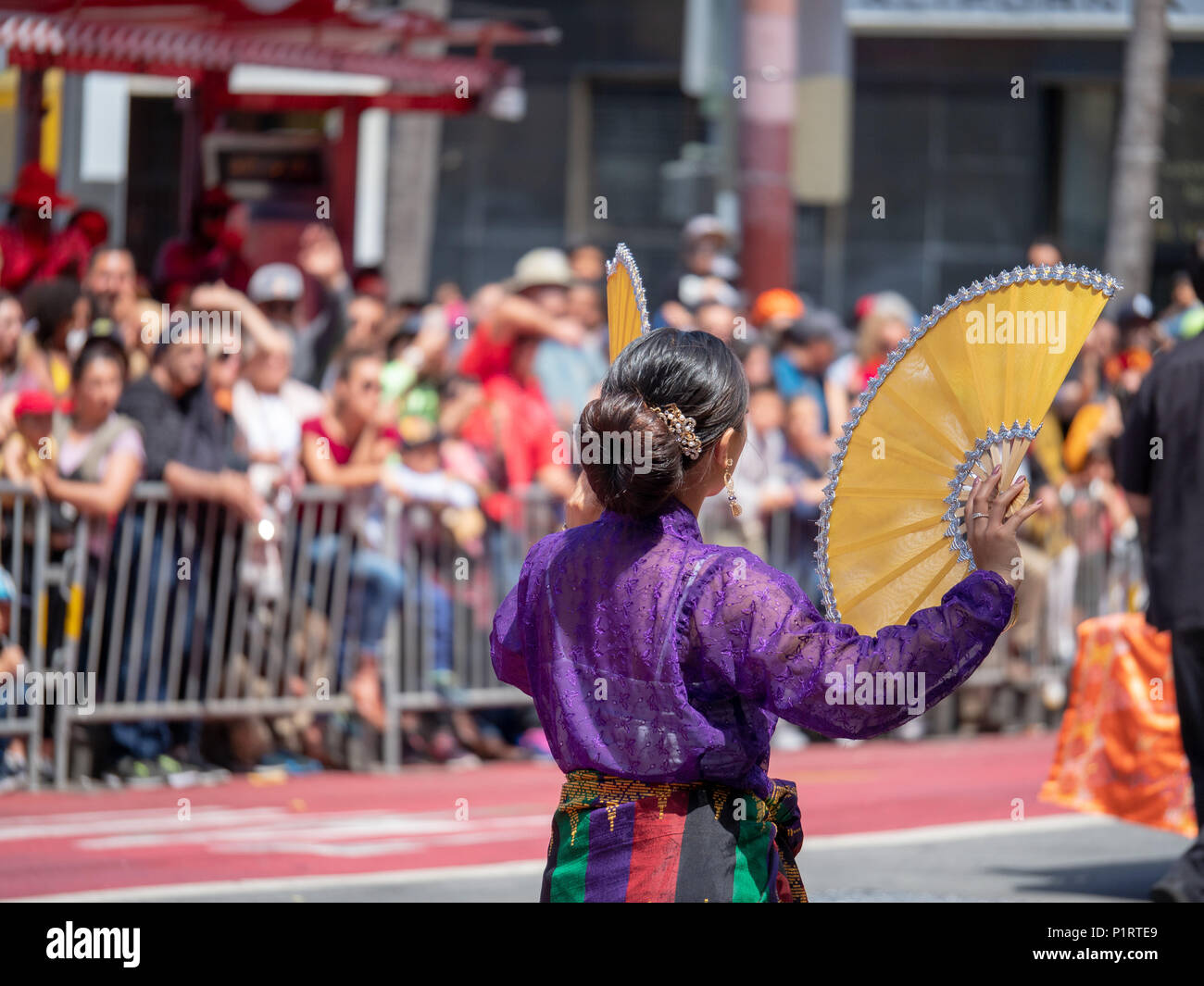 A woman dressed in traditional Mexican wear waves fans in front of ...