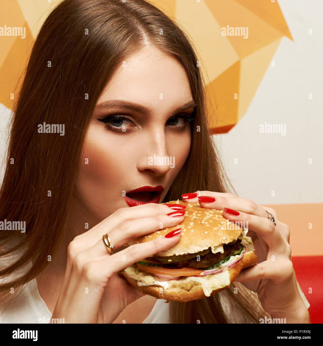 Portrait of gorgeous young woman with closed eyes and red lips holding ...