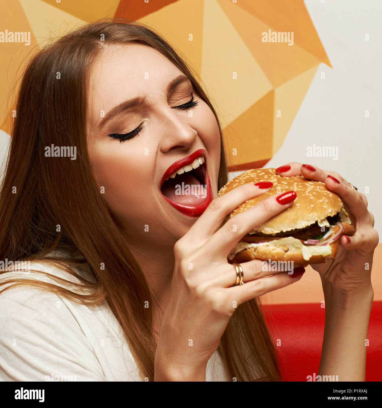 Portrait of gorgeous young woman with closed eyes and red lips holding ...