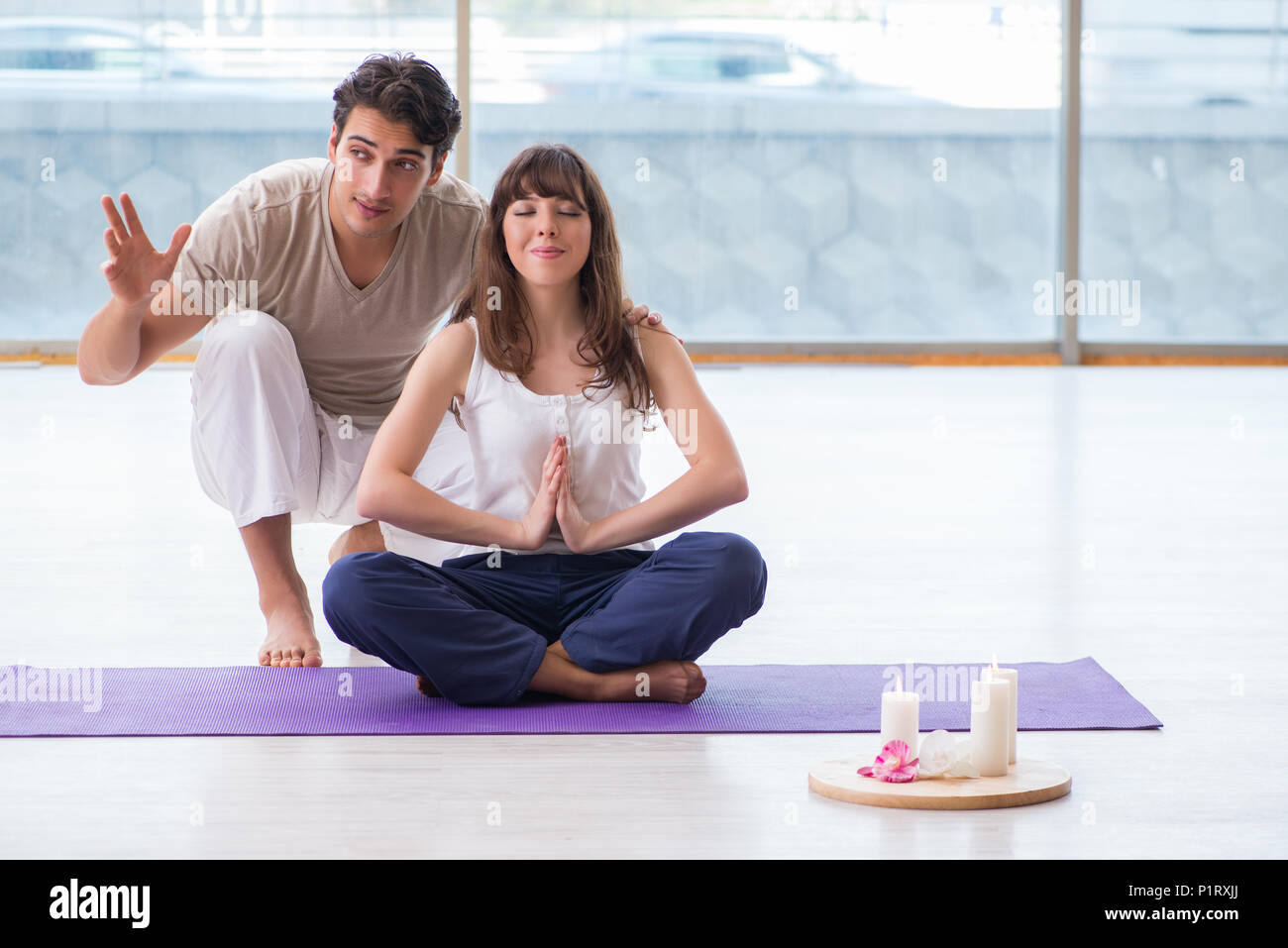 Personal coach helping during yoga session Stock Photo - Alamy
