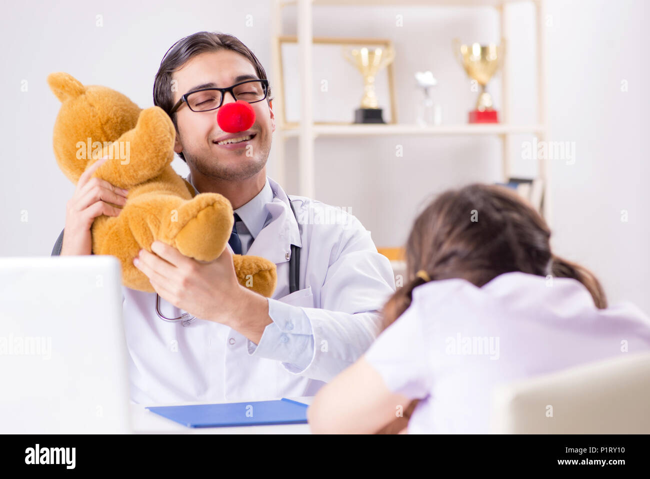 Funny pediatrician with little girl at regular check-up Stock Photo - Alamy