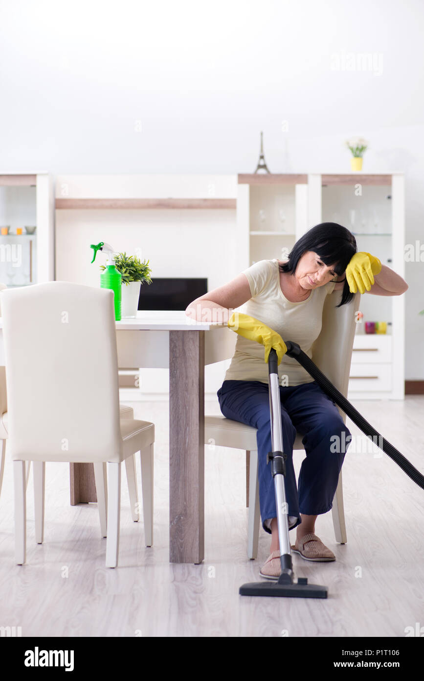 Senior old woman tired after vacuum cleaning house Stock Photo - Alamy