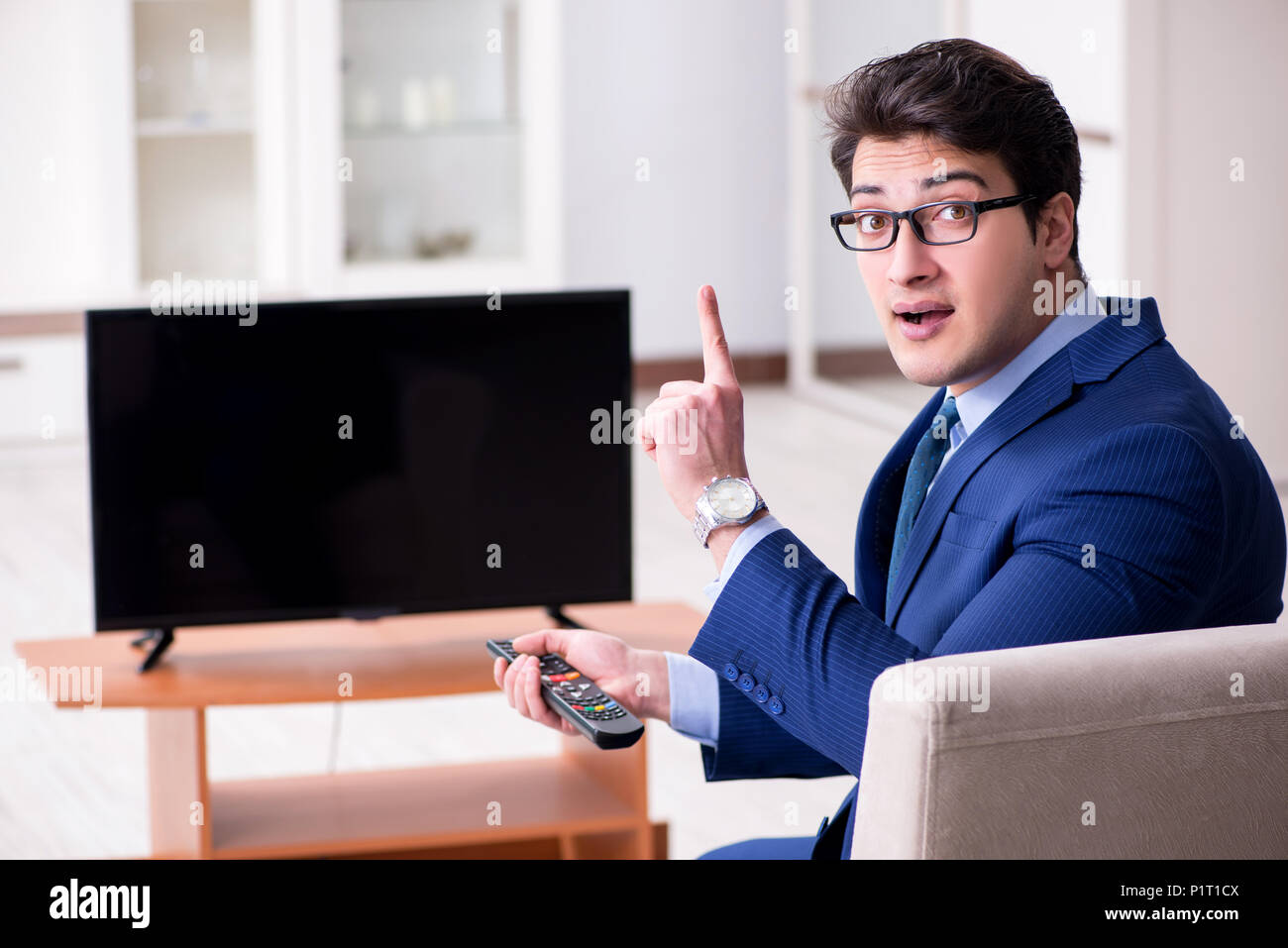 Businessman watching tv in the office Stock Photo - Alamy