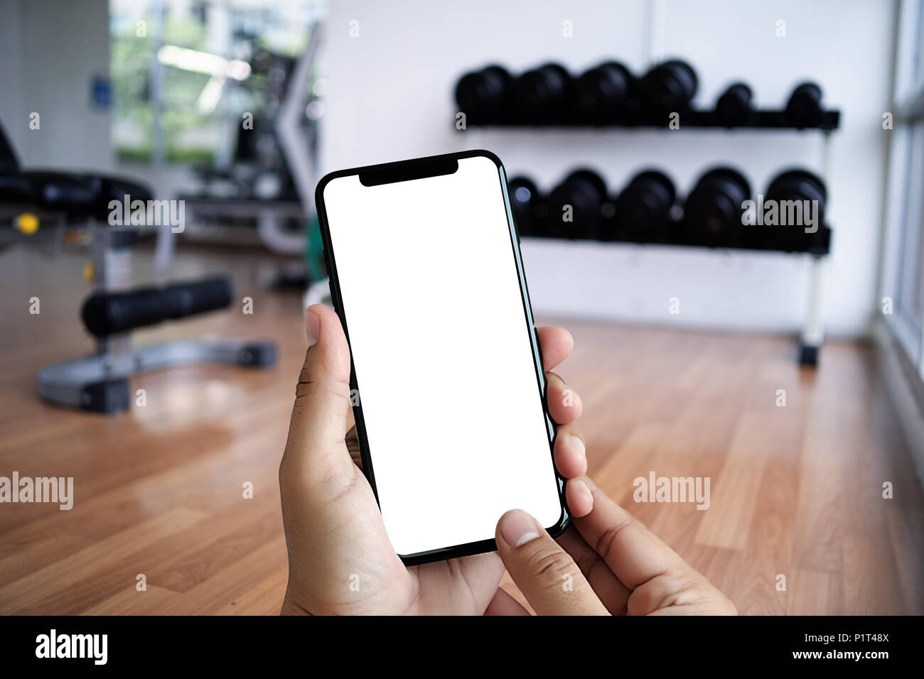 Young man Hand holding smartphone in gym to fitness phone fitness ...
