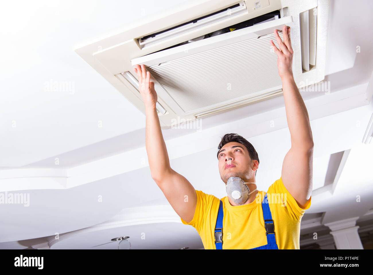 Repairman repairing ceiling air conditioning unit Stock Photo - Alamy