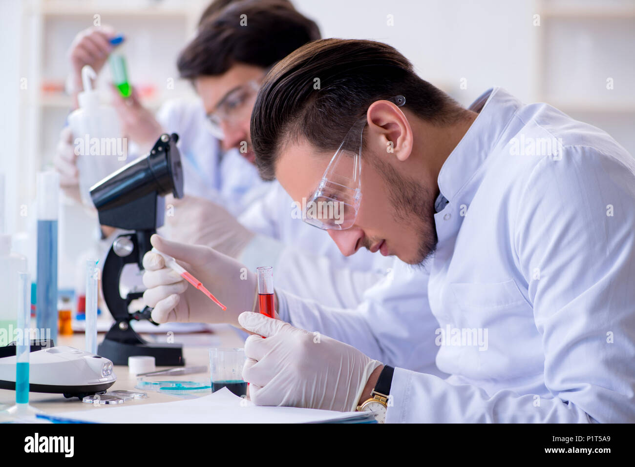 Team of chemists working in the lab Stock Photo - Alamy
