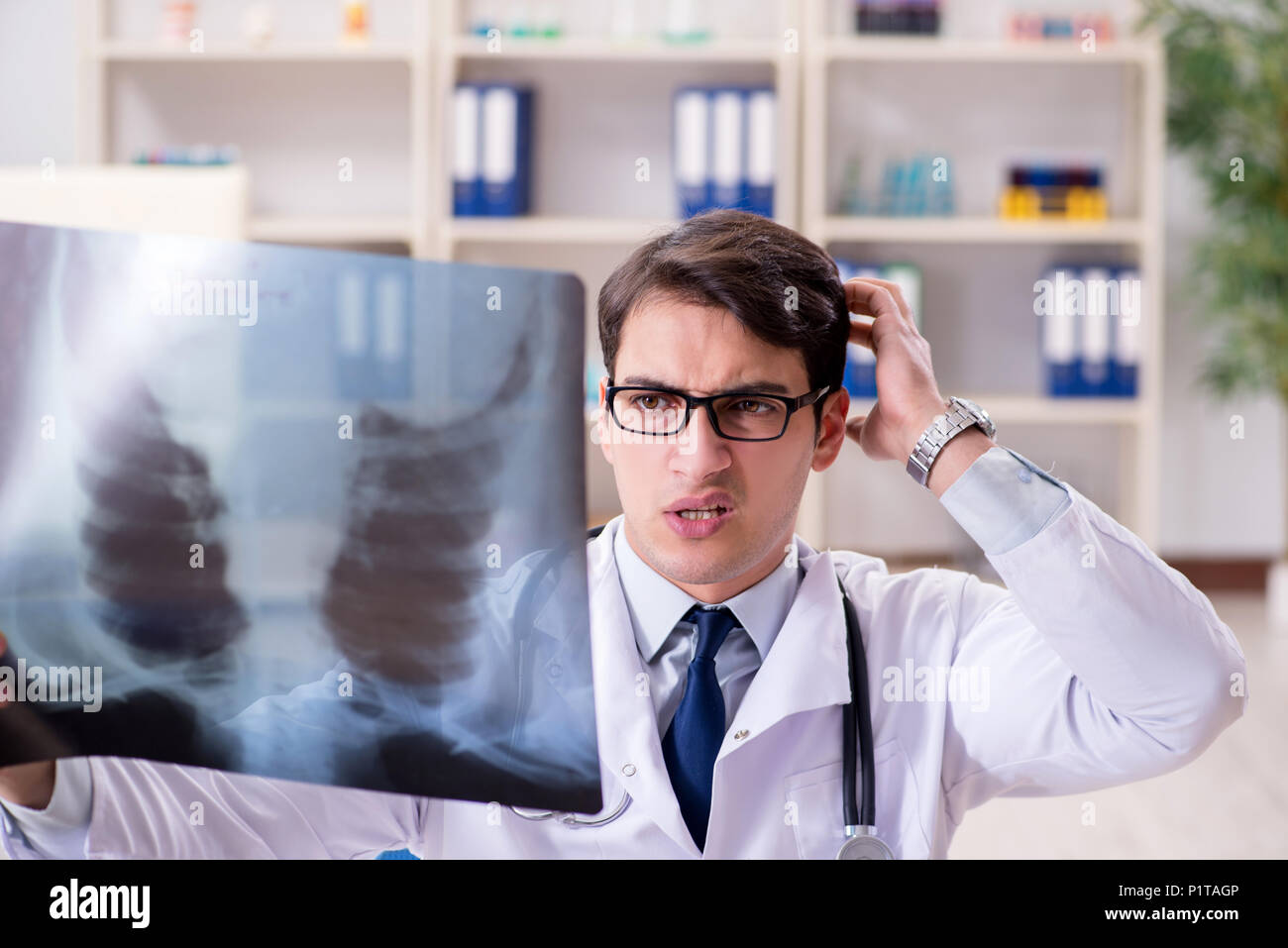 Young doctor looking at x-ray images in clinic Stock Photo - Alamy