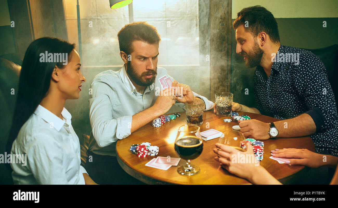 Side view photo of friends sitting at wooden table. Friends having fun ...