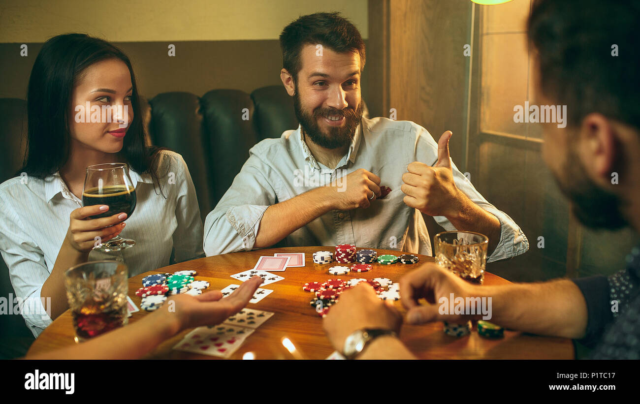 Side view photo of friends sitting at wooden table. Friends having fun ...