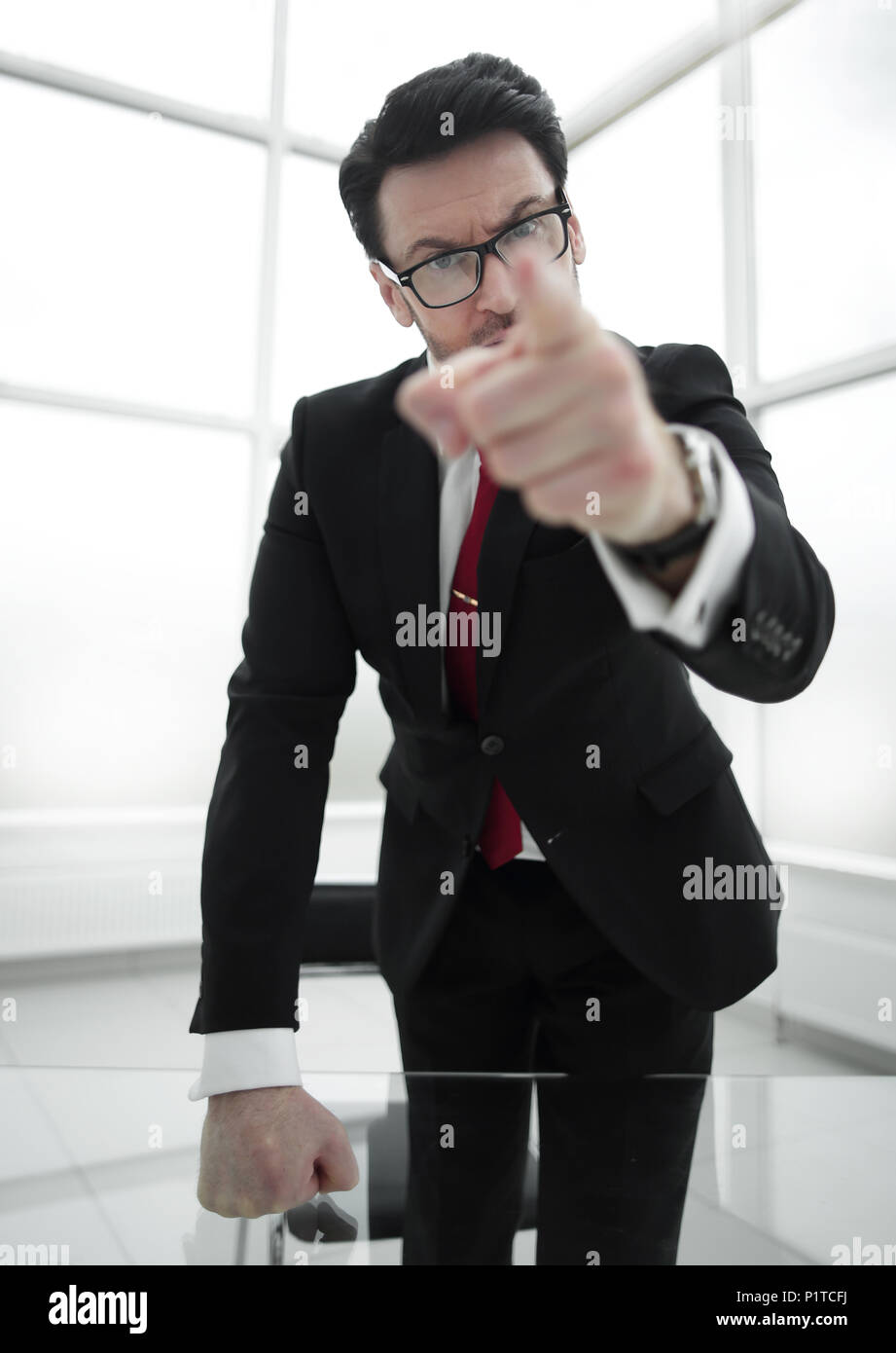 strict businessman pointing finger at you while standing in his office ...