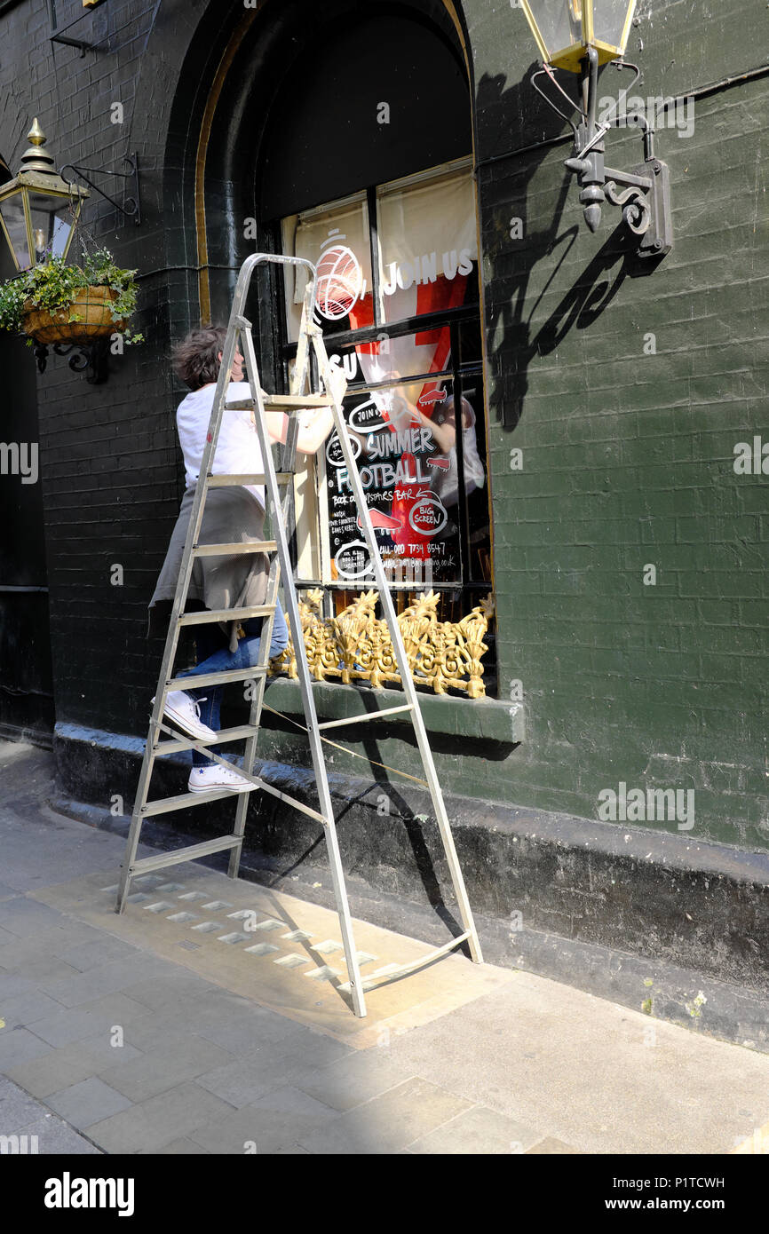 The Glassblower Pub, sign writer on step ladder, Soho, London, England ...